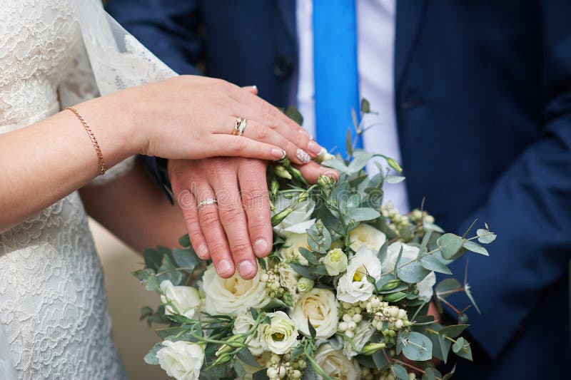 Hands of the Bride and Groom at a Wedding Bouquet Stock Photo - Image ...