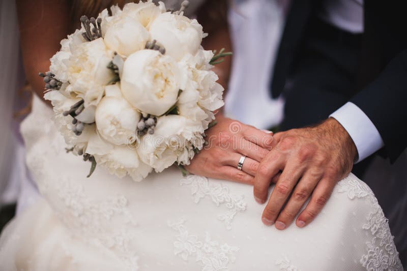 Hands of Bride and Groom with Wedding Bouquet. Stock Photo - Image of ...