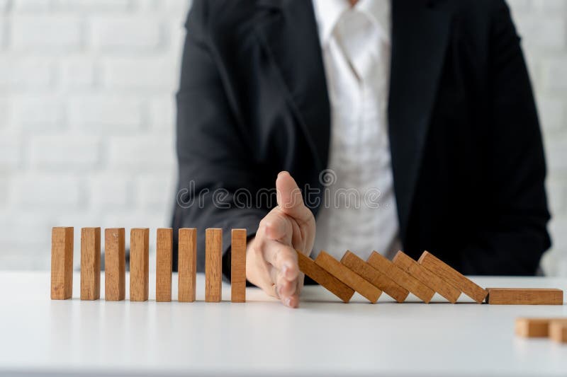 The Hands of a Businesswoman are Protecting the Dominoes Falling on the ...