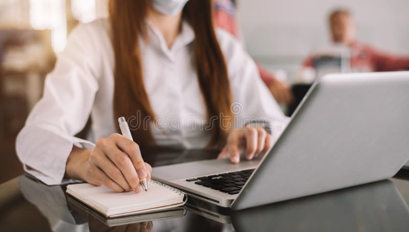 Hands Businesswoman Taking Notes in a Notebook and Using a Laptop in ...