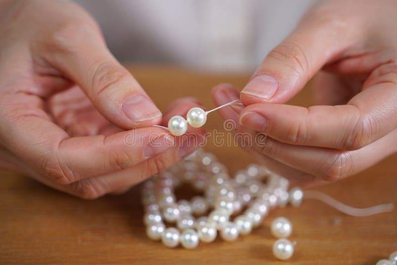 Hands Carefully Threading a Pearl Onto a String. AI Generated. Stock ...