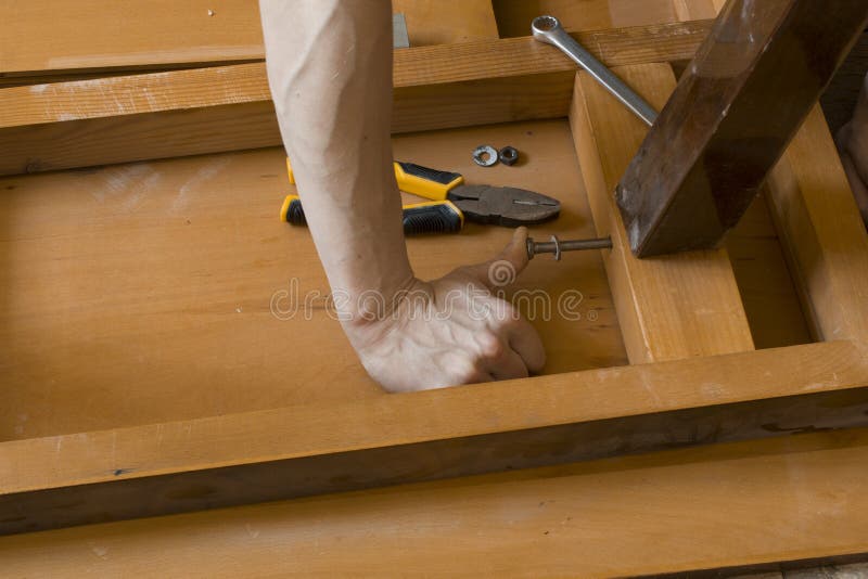 The Hands Of A Carpenter Assembling Wooden Furniture Close Up Stock