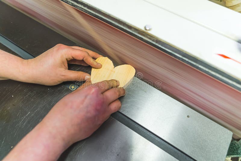 Hands of a Carpenter Shaping a Piece of Wood Using a Grinding Machine ...