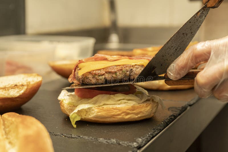The Hands of a Chef Assembling a Great and Delicious Beef Burger with ...