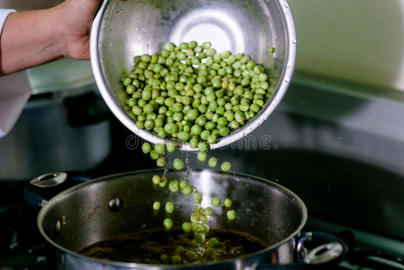 Hands cooking fresh peas. stock photo. Image of meal - 185589568