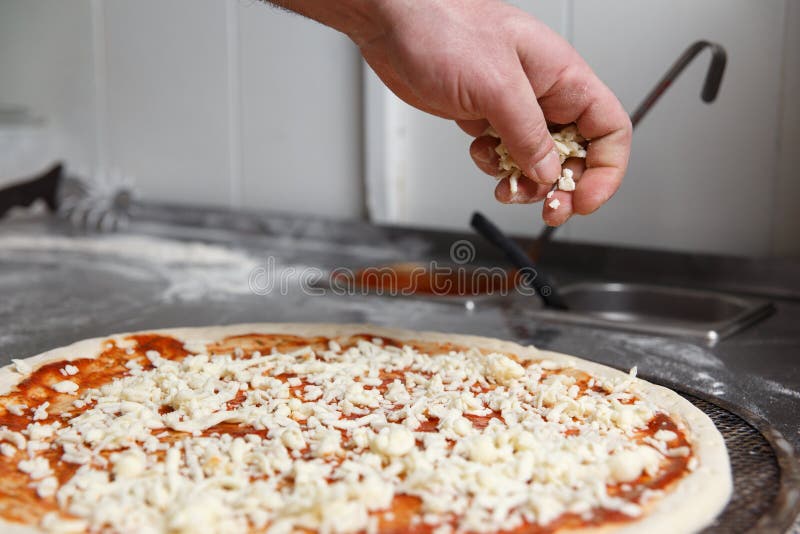 Chef Sprinkling Pizza With Cheese At The Kitchen Stock Image - Image of ...