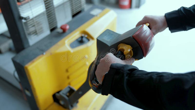 Hands on the Control Lever of a Hydraulic Stacker. a Worker Lifts Loads ...