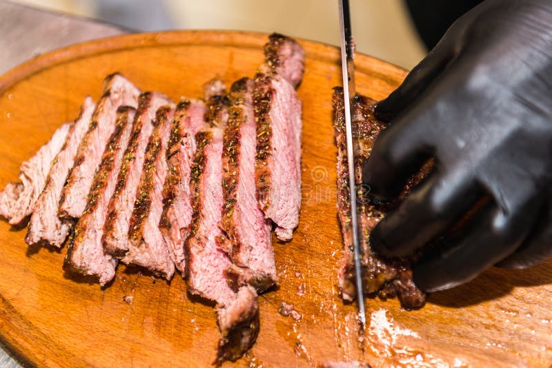 Hands cook cut fried meat stock image. Image of dish - 113100833