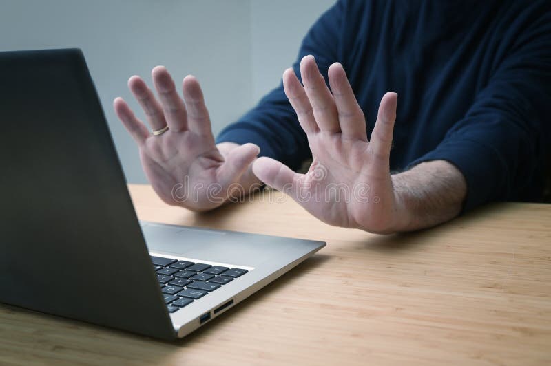 Hands in Defensive Gesture Against a Laptop Computer, Avoiding Further ...