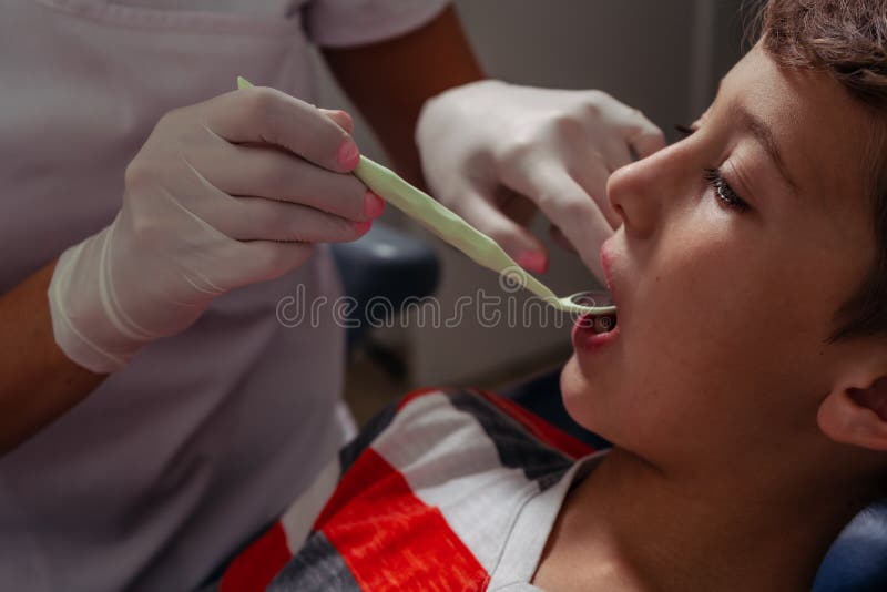 A Hands of the Dentist with the Speculum Checking the Teeth of the ...