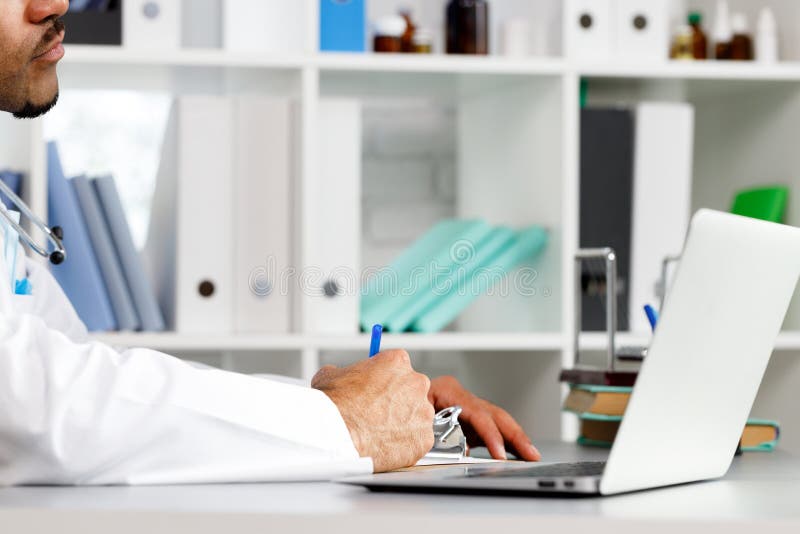 Hands of a Doctor Writing Something on Clipboard while Sitting at ...