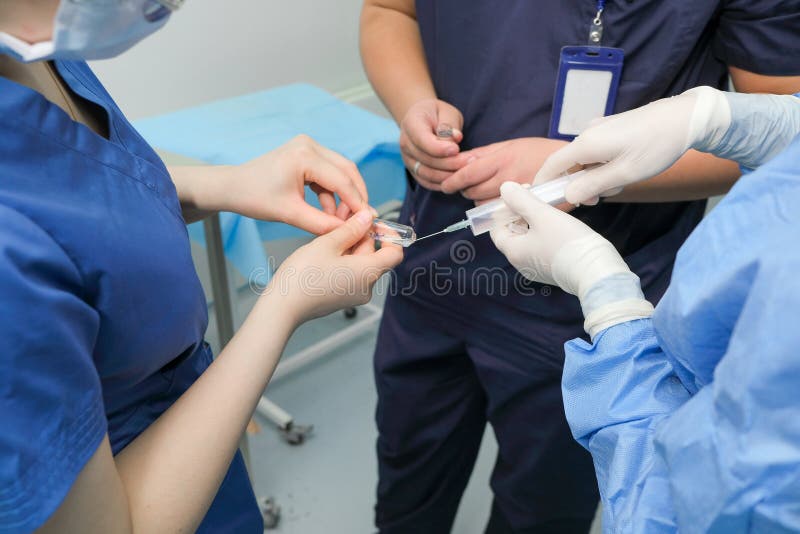 The Hands of Doctors Fill the Syringe with Drugs from the Ampoule Stock ...