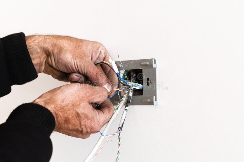 The Hands of an Elderly Man Mount a Rosette in a White Wall. Repair of ...