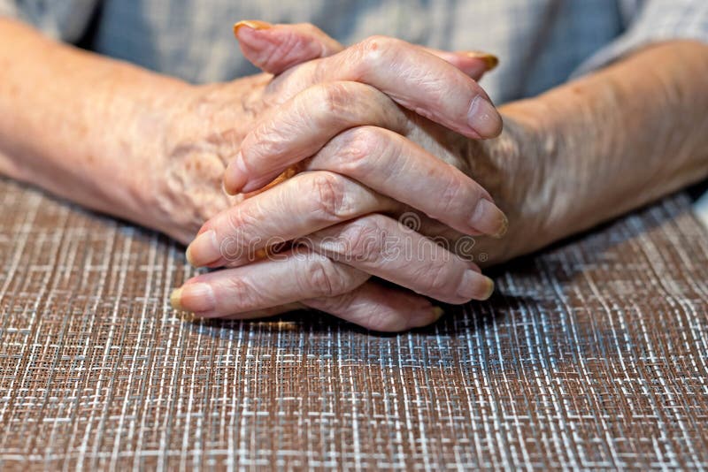 The Hands of an Elderly Woman Resting on the Table. Parkinson Stock ...