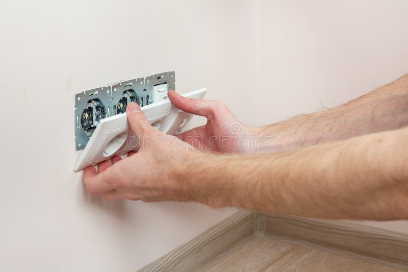 The Hands of an Electrician Installing a Wall Power Socket. Stock Image ...