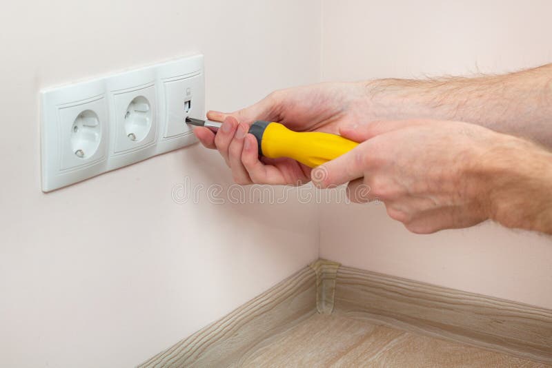 The Hands of an Electrician Installing a Wall Power Socket. Stock Photo ...