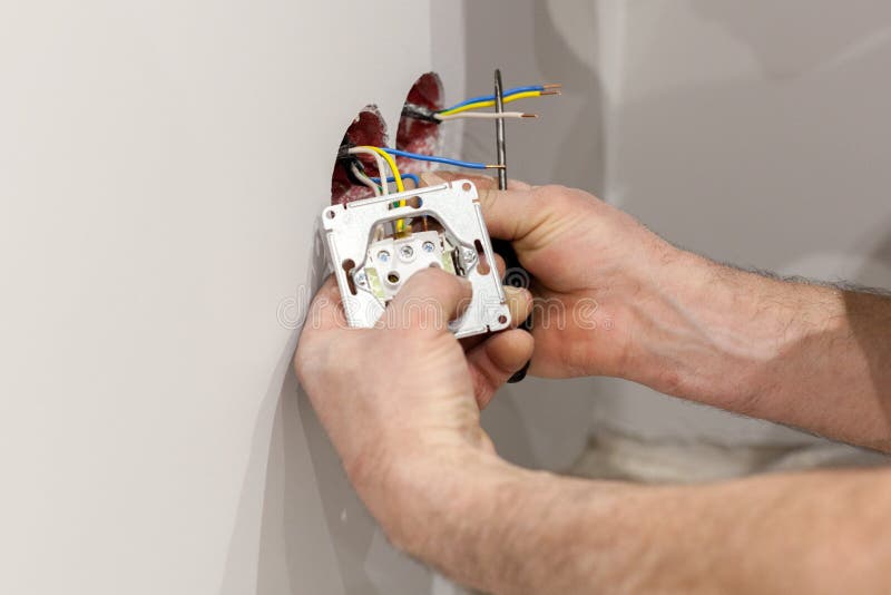 The Hands of an Electrician Installing a Wall Power Socket. Stock Photo ...