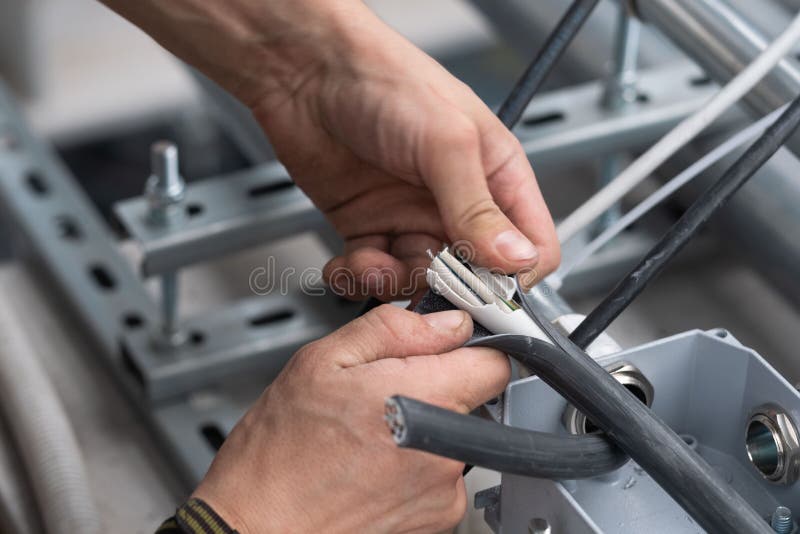 The Hands of an Electrician Strips the Ends of the Cable To Connect To ...