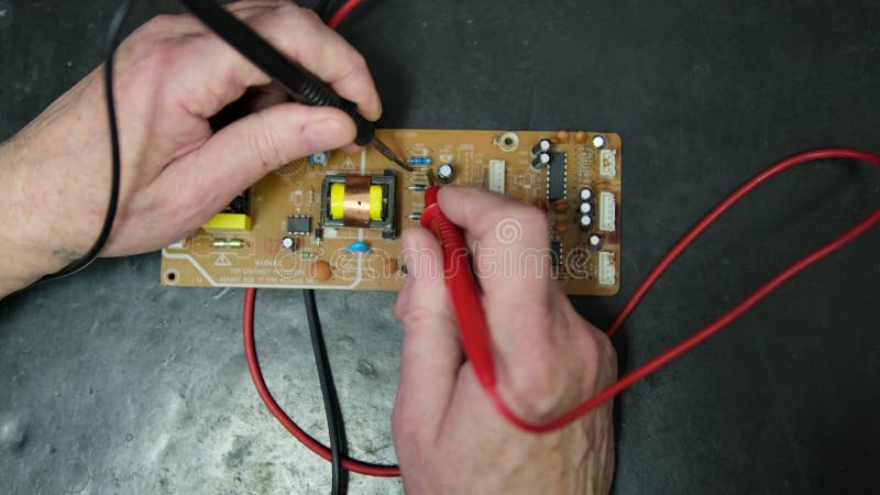 Close-up of an Electrician Hands Testing an Electronic Circuit Board ...