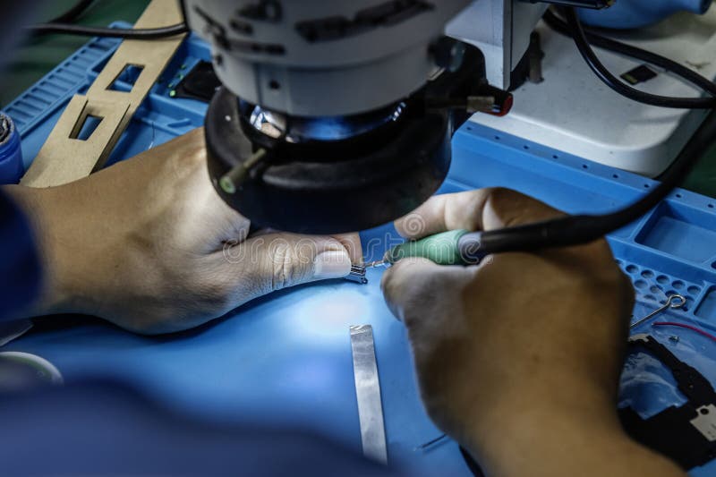 The Hands of an Electronic Repair Shop Operator Under an Electron ...