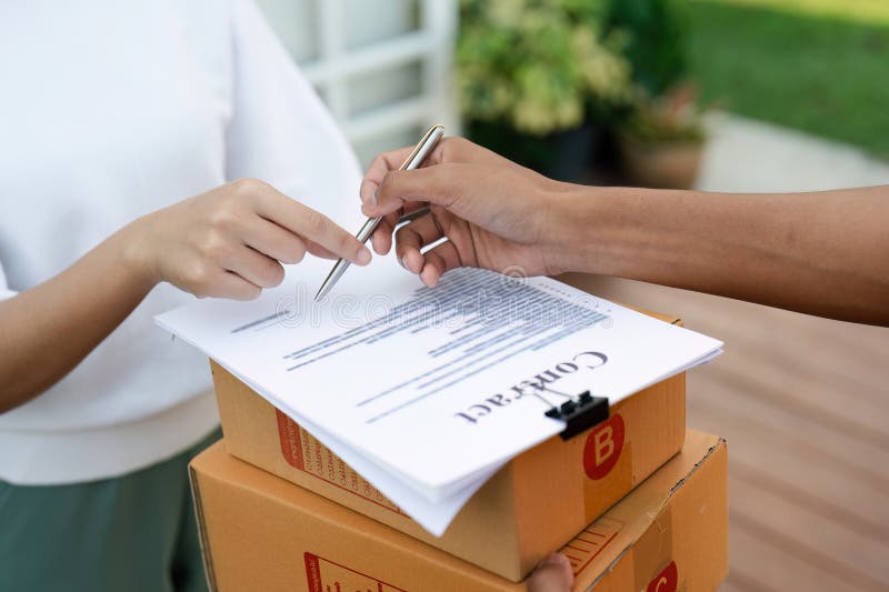 Close Up of Hands Exchanging a Delivery Package and Signing a Contract ...