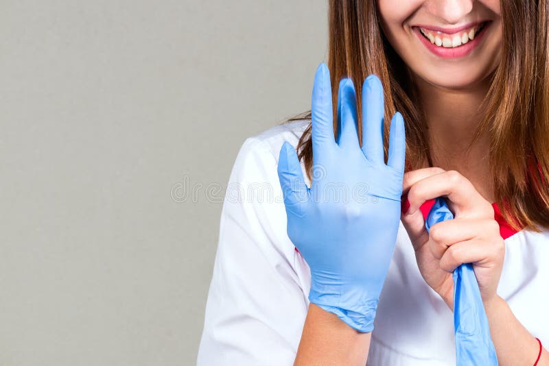 Hands And Face Of A Woman Doctor Close Up Puts On Sterile Glove Stock
