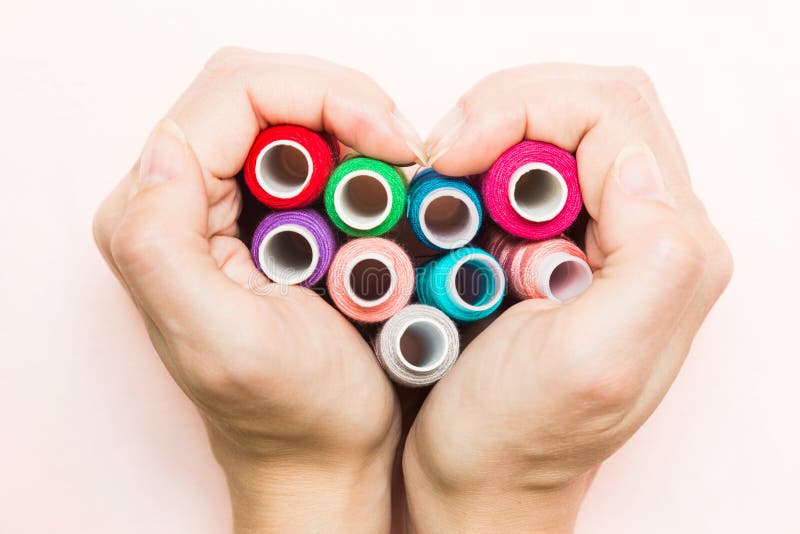 Hands Folded in the Shape of a Heart with Spools of Thread. Stock Image ...