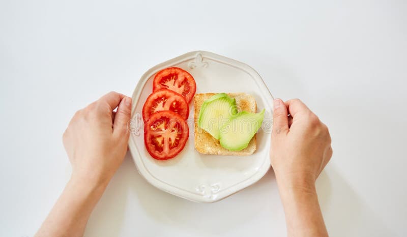 Hands in Front of Toast with Avocado and Tomato Stock Photo - Image of ...