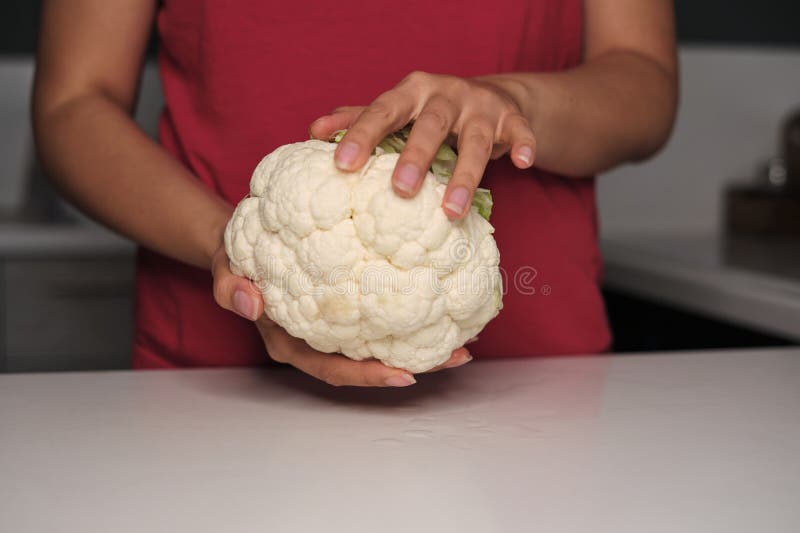 Hands Gently Holding a Fresh Head of Cauliflower, Highlighting the ...