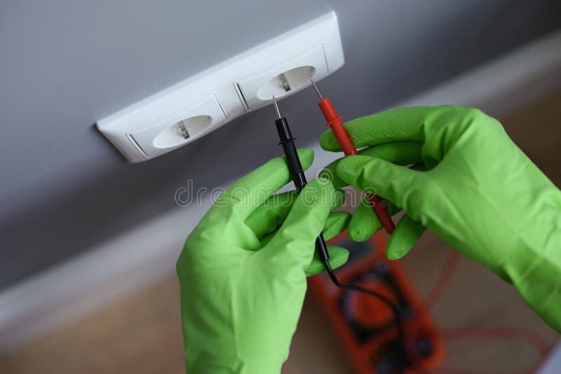Hands in Gloves Measure the Voltage in the Outlet with a Tool Stock ...