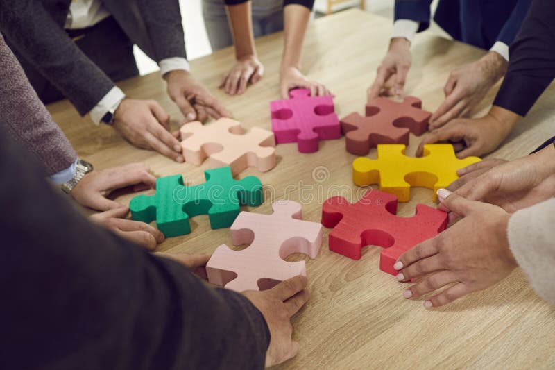 Hands of a Group of Business People Assembling Jigsaw Puzzle ...