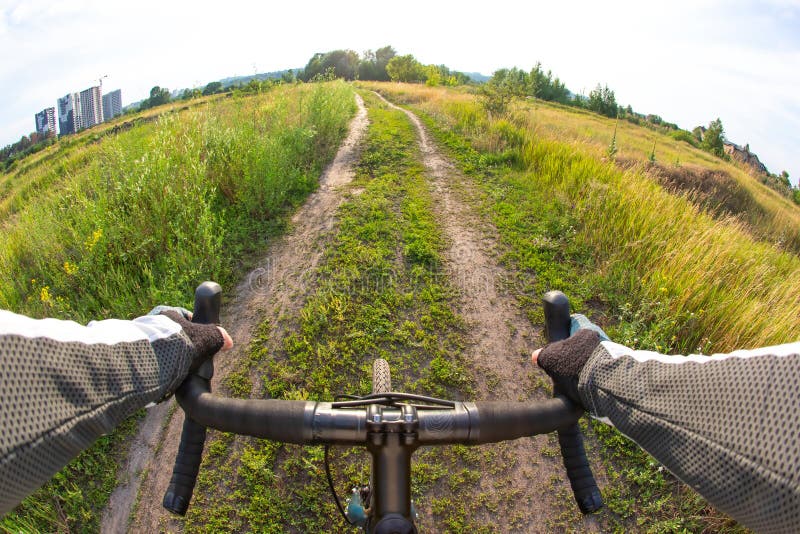 Hands on the Handlebars of a Bicycle of a Cyclist Riding Along a Trail ...