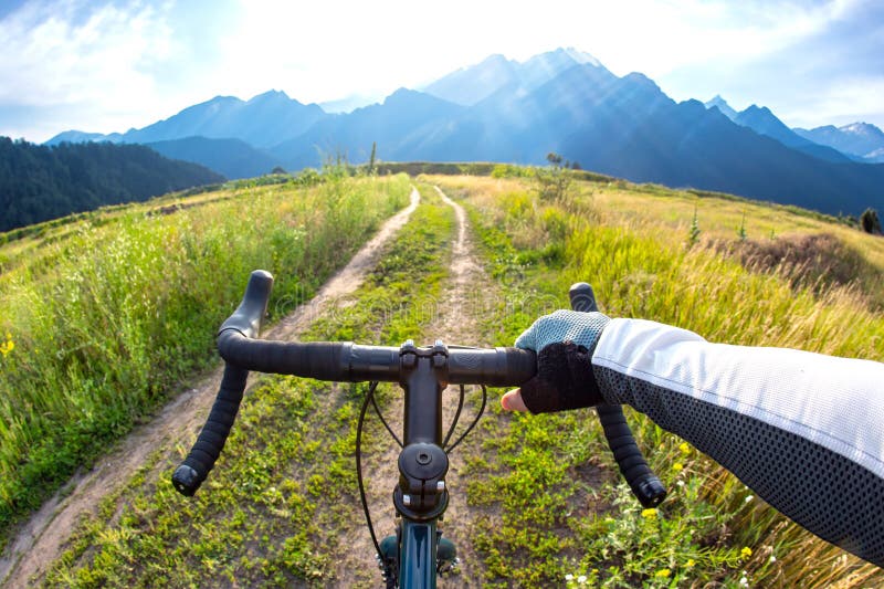Hands on the Handlebars of a Bicycle of a Cyclist Riding Along a Trail ...