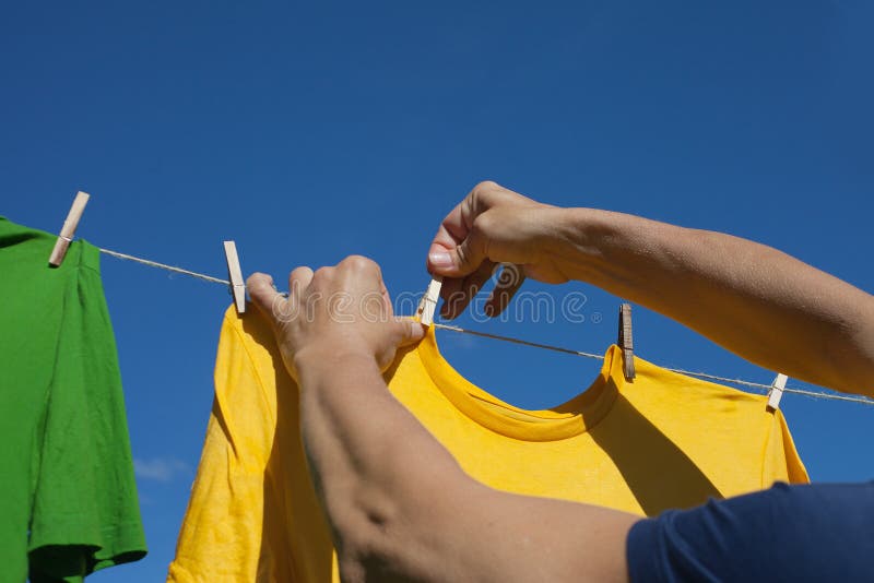 Hands hanging clothes. stock image. Image of domestic - 26395543