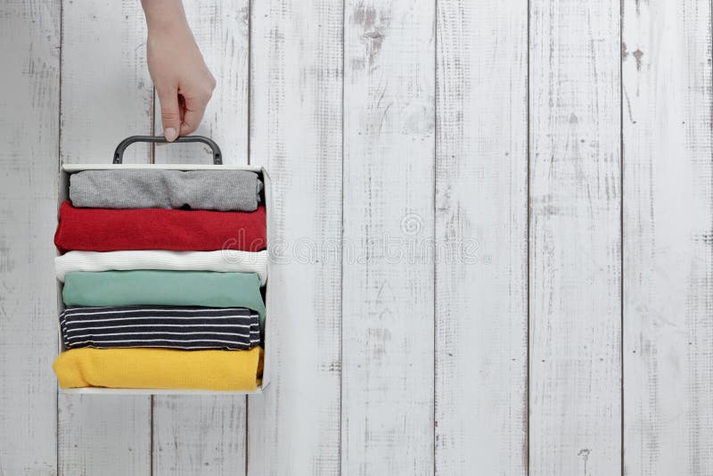 Hands Hold a Container with Neatly Folded Clothes; Storage of Things ...