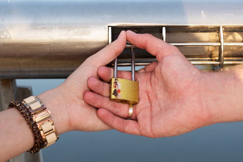 The Hands Hold the Lock Buttoned on the Railing of the Bridge Stock ...