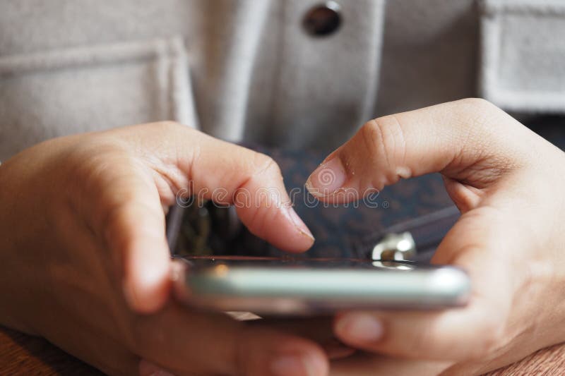 Person Using Smartphone while Sitting at Wooden Table Stock Photo ...