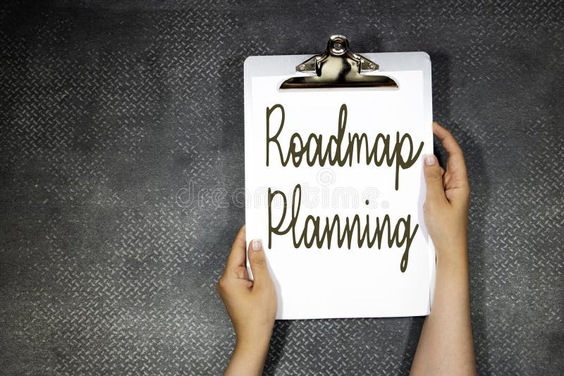 Hands Holding a Clipboard with Roadmap Planning Text . Stock Image ...