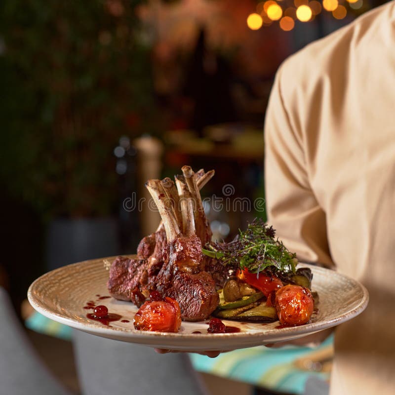 Hands Holding Cooked Tomahawk Long Bone Ribeye Steak on a Serving Board ...