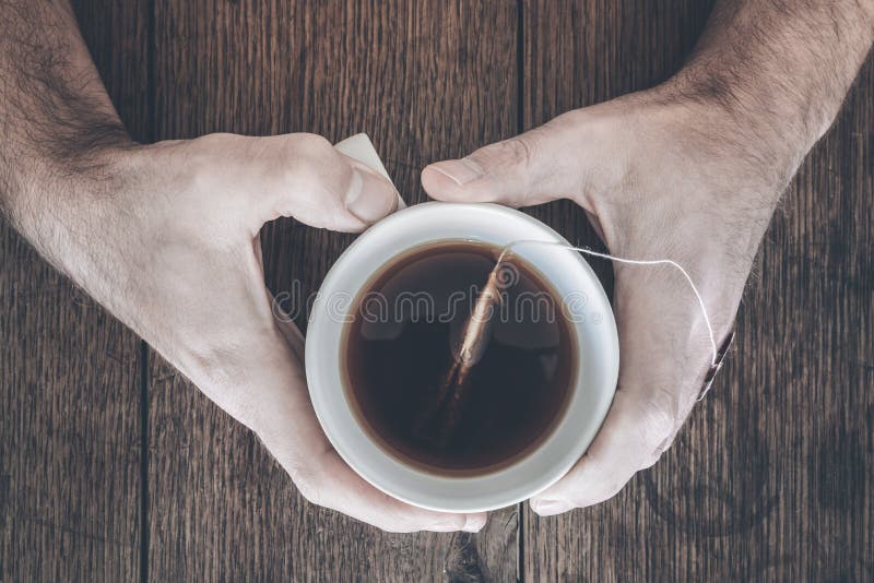 Hands Holding Cup of Steaming Hot Tea on Rustic Wooden Table Stock ...