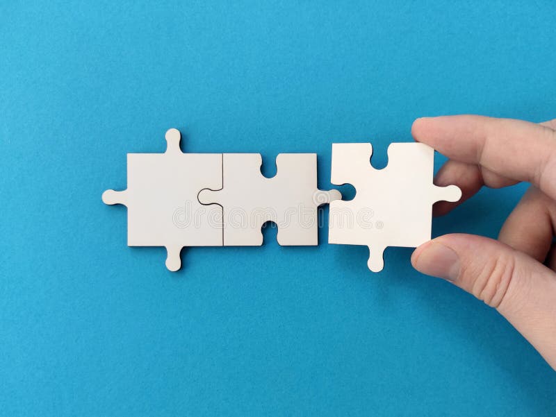 Hands Holding Jigsaw Puzzle Pieces on Blue Background, Hand Assembling ...