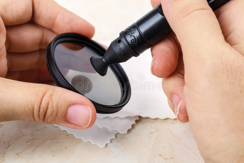 Hands Holding a Lens Pen and Cleaning a Camera Polarizing Filter with ...