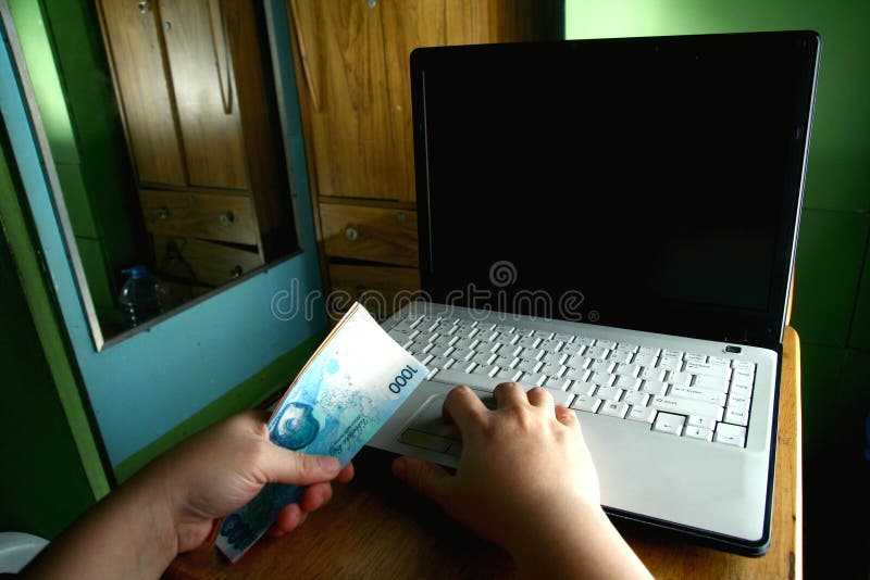 Hands Holding Money while Working on a Computer Laptop Stock Photo ...