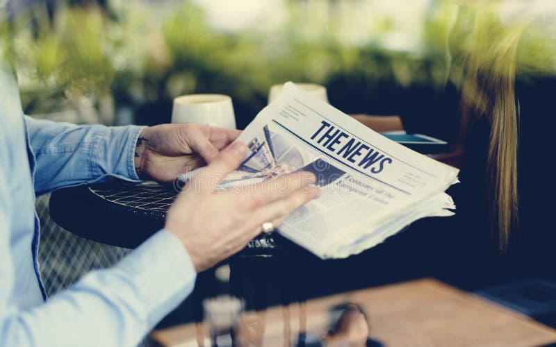 Hands Holding a Newspaper Reading at the Cafe Stock Photo - Image of ...