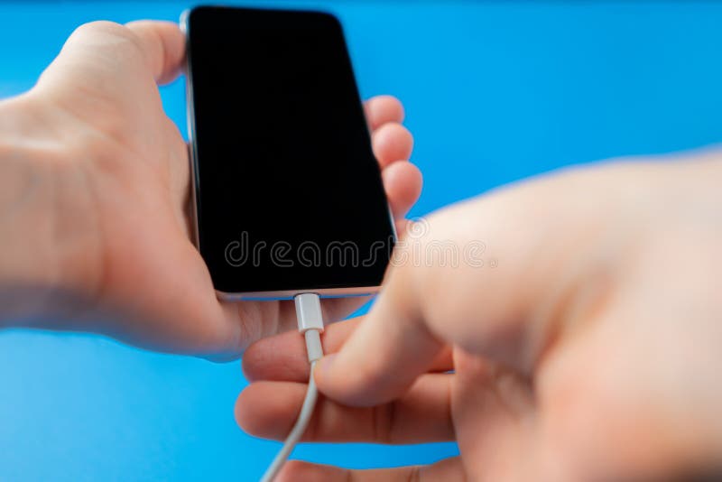 Hands Holding a Smartphone and Charging Wire, a Low Battery Stock Photo ...