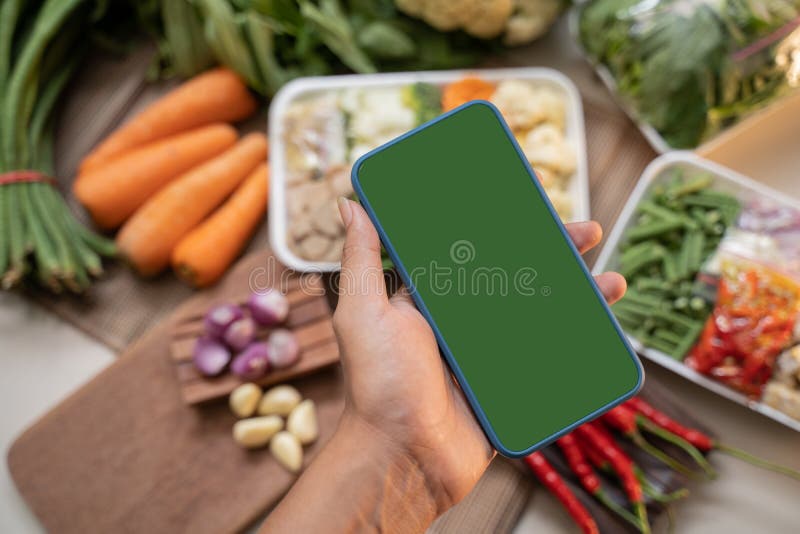 Hands Holding a Smartphone with a Vegetable Background Stock Image ...