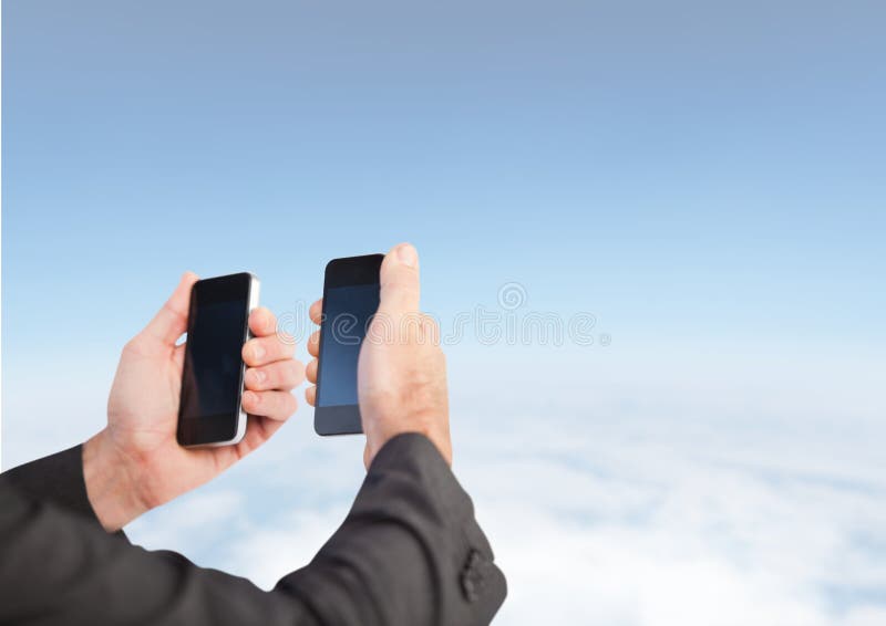 Hands Holding Two Phones at Same Time Against Blue Sky Stock Photo ...