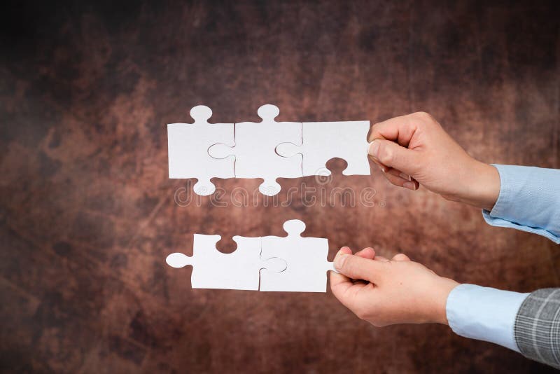 Hands Holding Two Pieces of Jigsaw Puzzle.Cooperation for Finding and ...