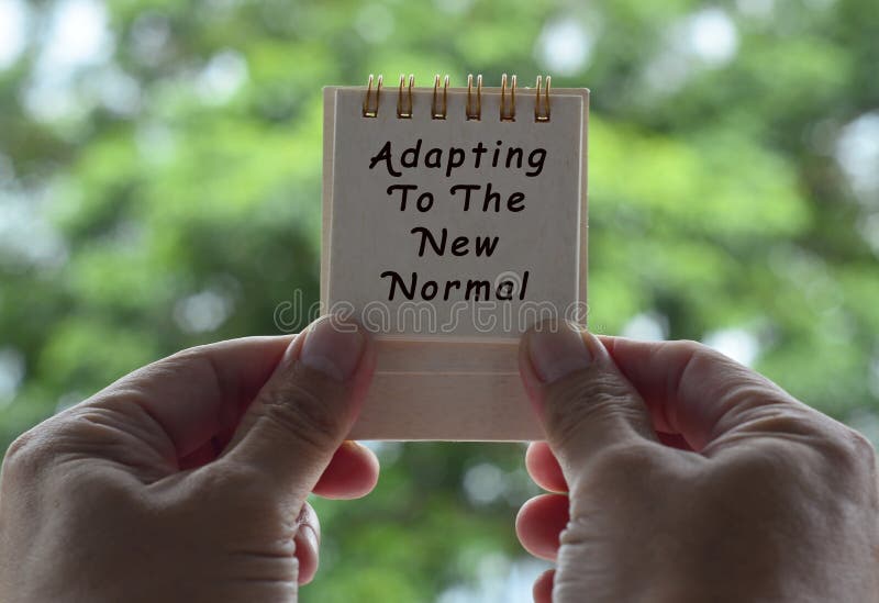 Hands Holding a White Notepad with Text Written and Blurred Green ...