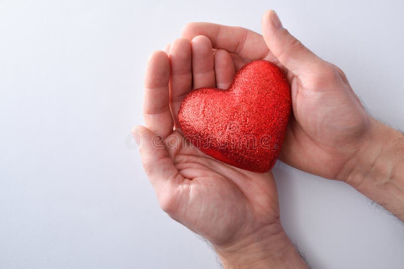 Hands Hugging a Red Glitter Heart on White Table Stock Photo - Image of ...